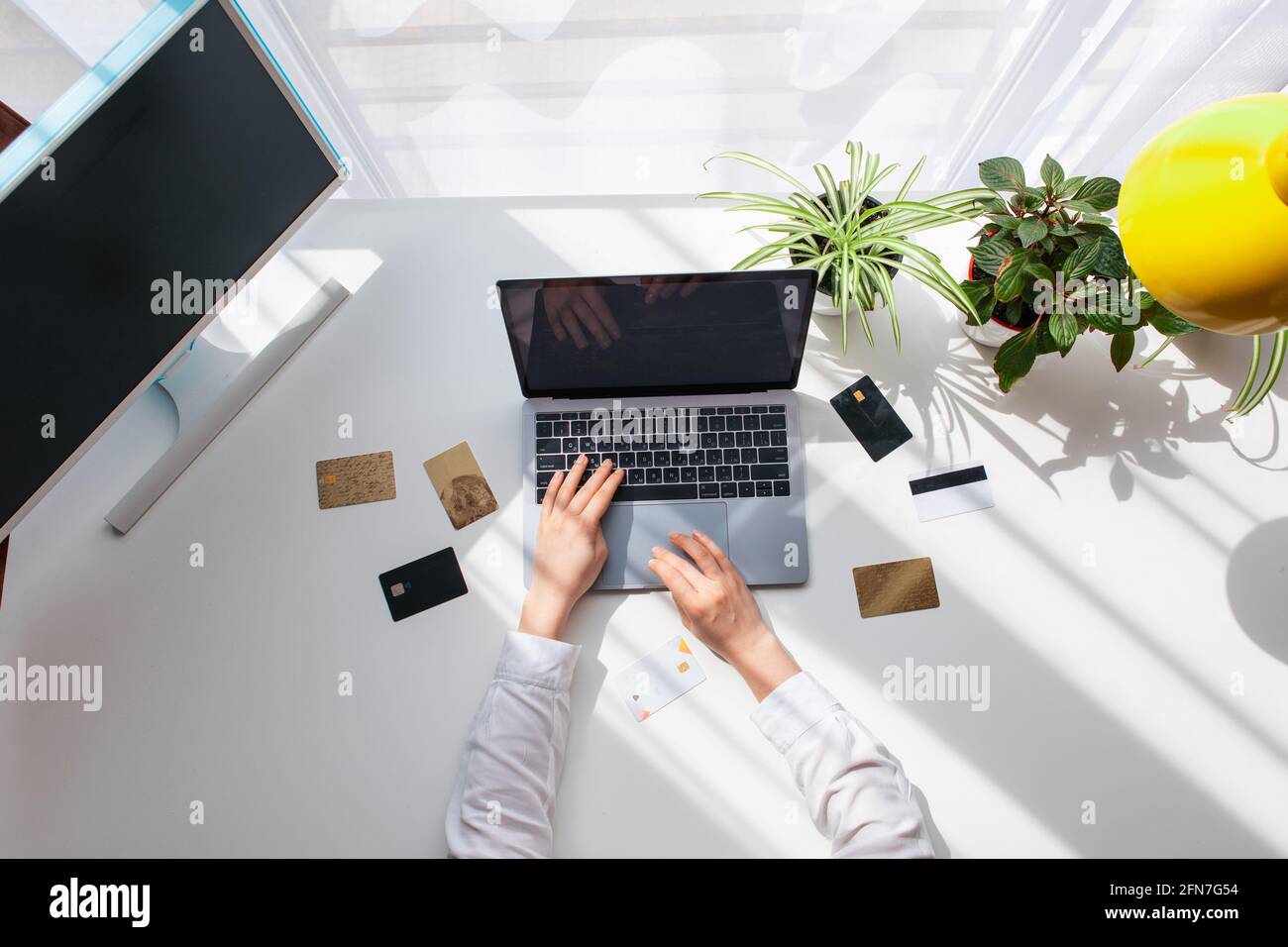 overhead top view hands on laptop keyboard. bank credit cards around ...