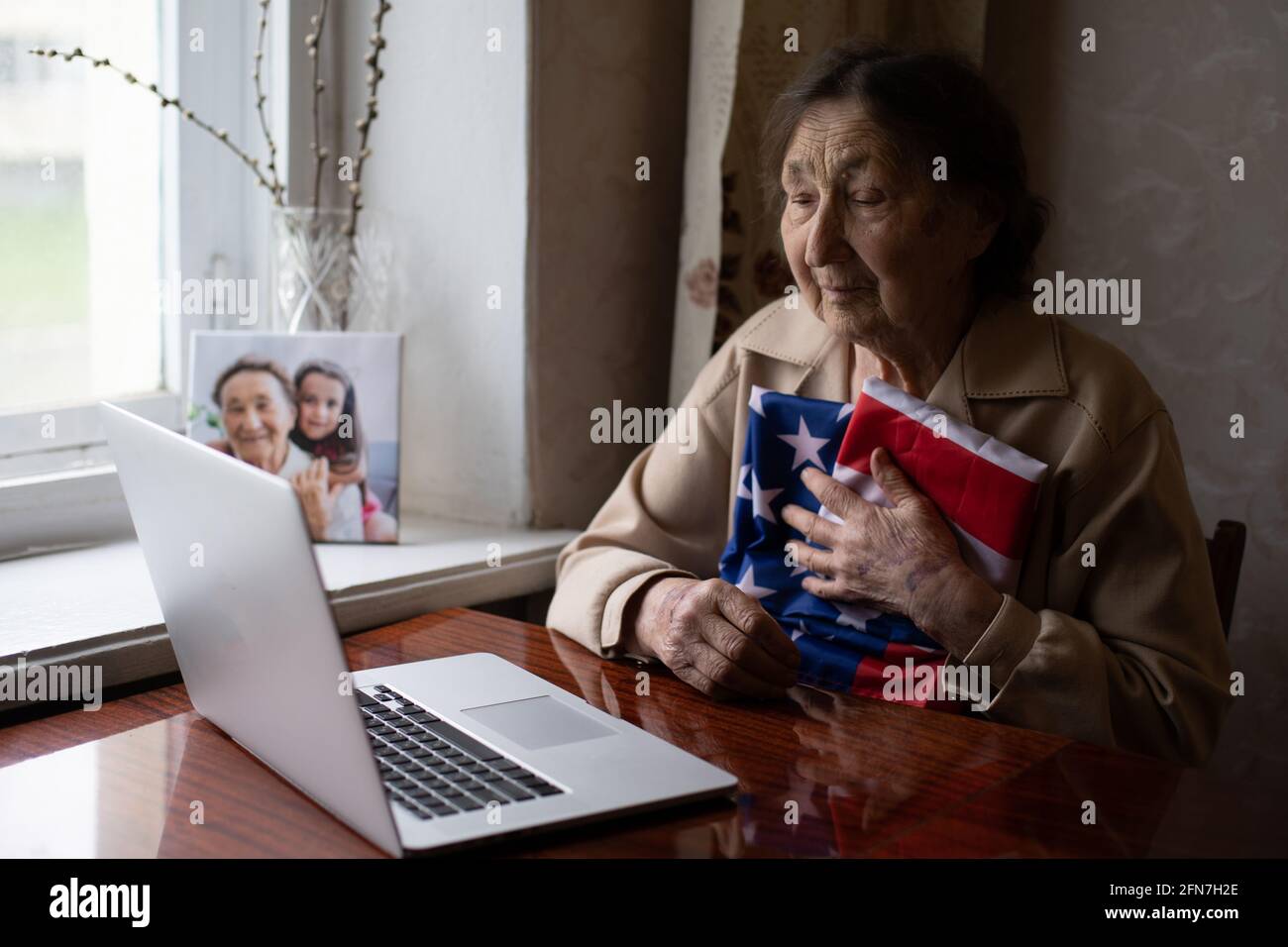 Independence Day celebration after quarantine. Granny looking at laptop ...