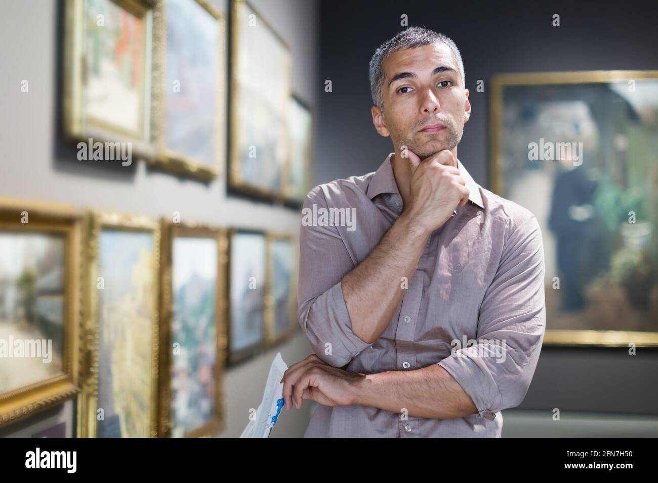 Adult man is visiting museum and looking at the pictures Stock Photo ...