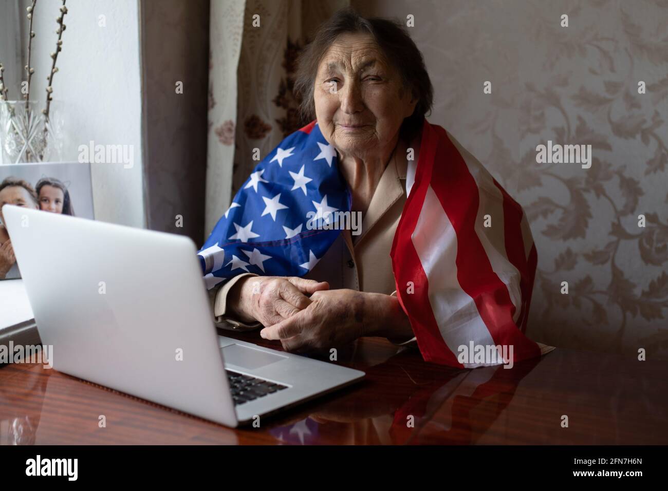 Independence Day celebration after quarantine. Granny looking at laptop ...