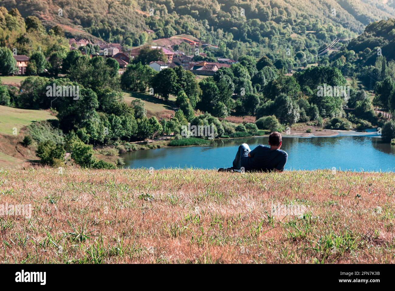 Man lying in the meadow looking at the landscape on the route linking ...