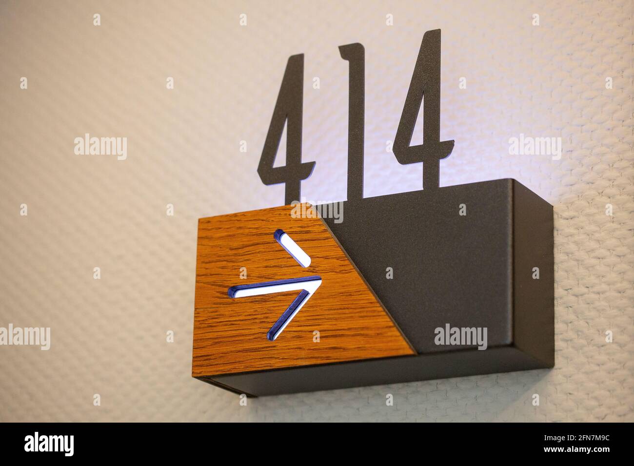 Closeup of 414 hotel room number with an arrow sign showing the ...