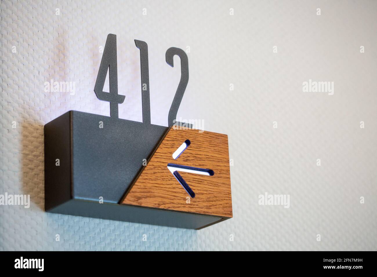 Closeup of 412 hotel room number with an arrow sign showing the ...