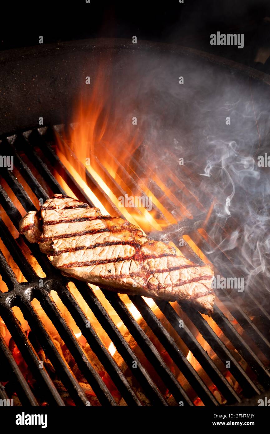 Grilling steak on the hot fire and smoke on the bbq Stock Photo - Alamy