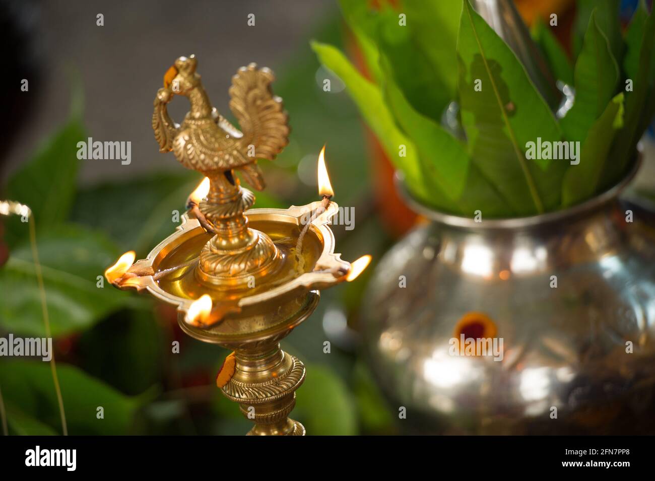 Samai oil lamp next to metal kalasha (metal pot) with leaves Stock ...