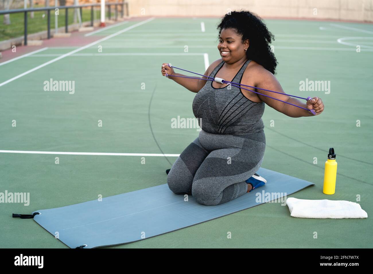 Curvy Afro woman doing workout exercises session - Young African female ...