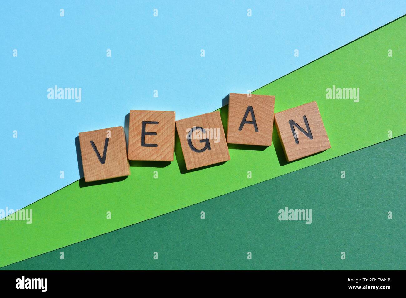 Vegan, word in wooden alphabet letters isolated on colourful background ...
