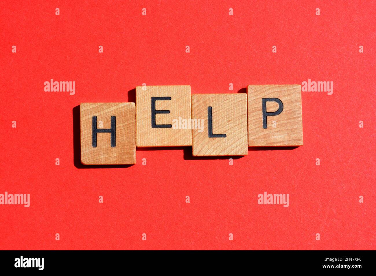 Help, word in wooden alphabet letters isolated on bright red background ...