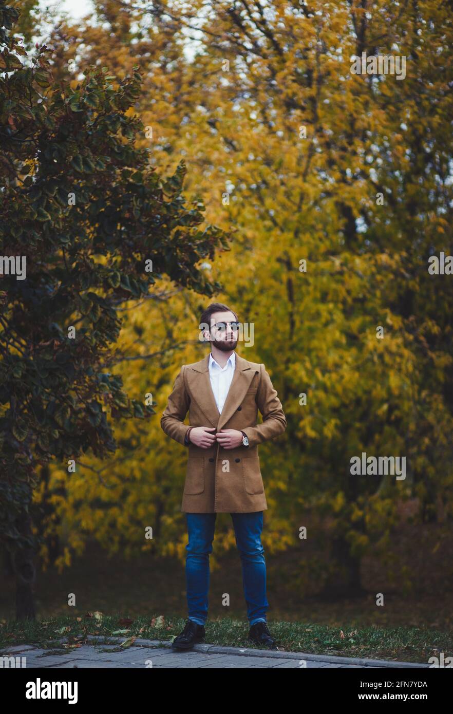 full height portrait of a business man in a coat and jeans Stock Photo ...