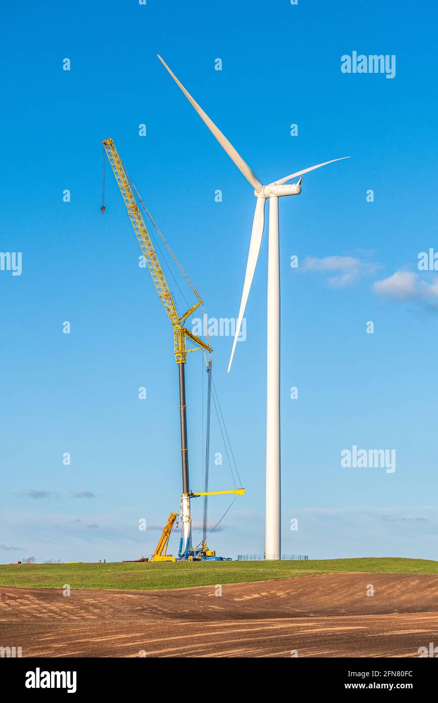 Wind turbine under construction near a village in a agricultural field ...