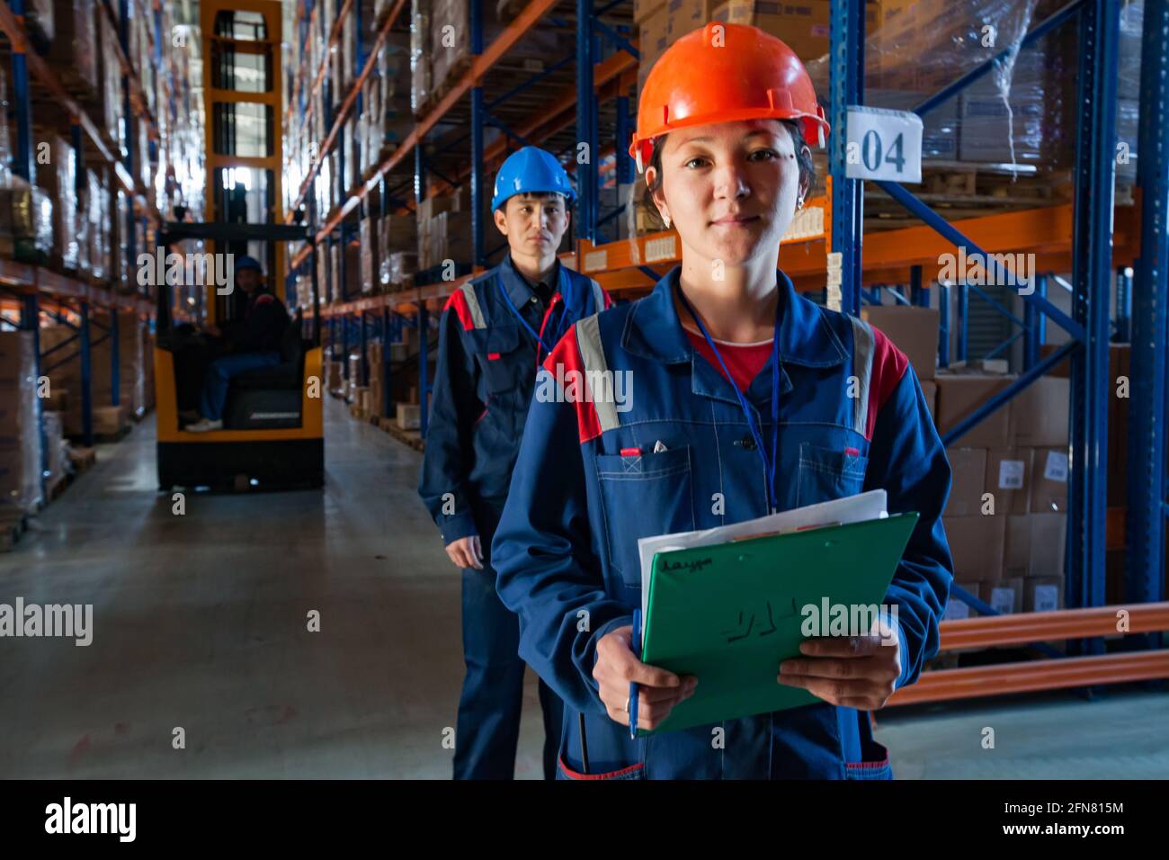 Modern logistic centre and warehouse. Two young Asian operators in ...