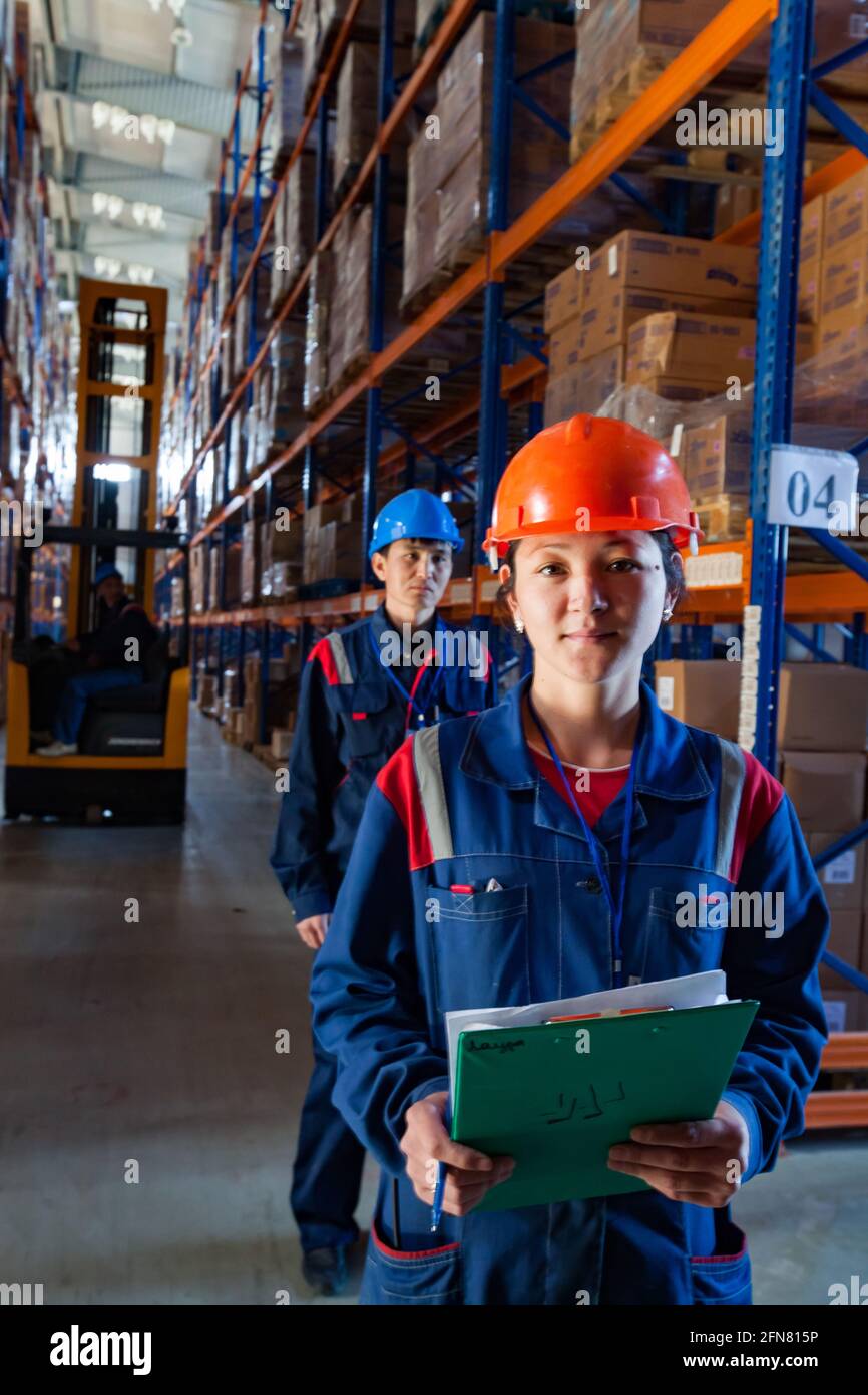 Modern logistic centre and warehouse. Two young Asian operators in ...