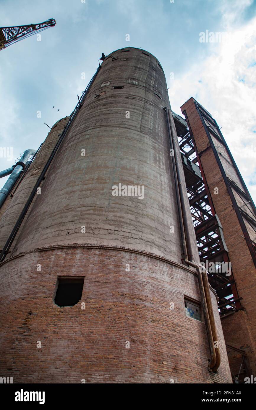 Outdated Soviet cement plant. Brick and concrete cement silo (tower ...