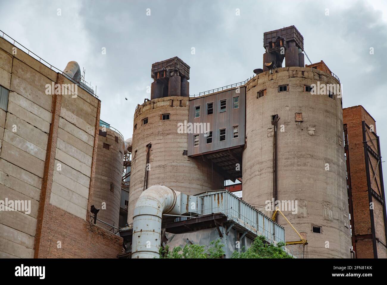 Old outdated Soviet cement plant obsolescent cement silos (towers ...