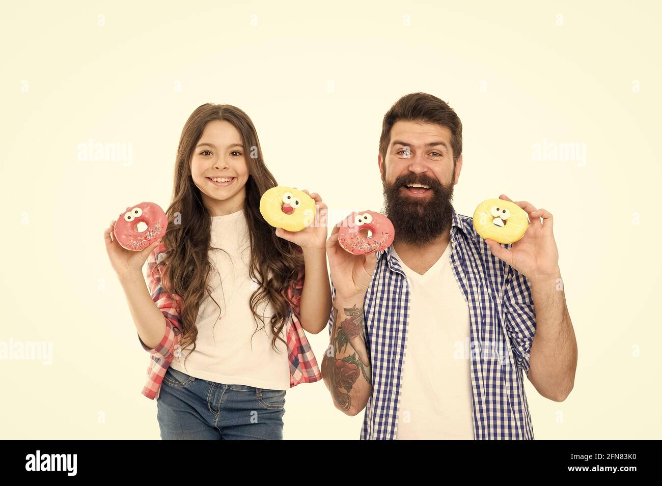 Come taste the paradise. Happy family hold funny donuts. Enjoying food ...