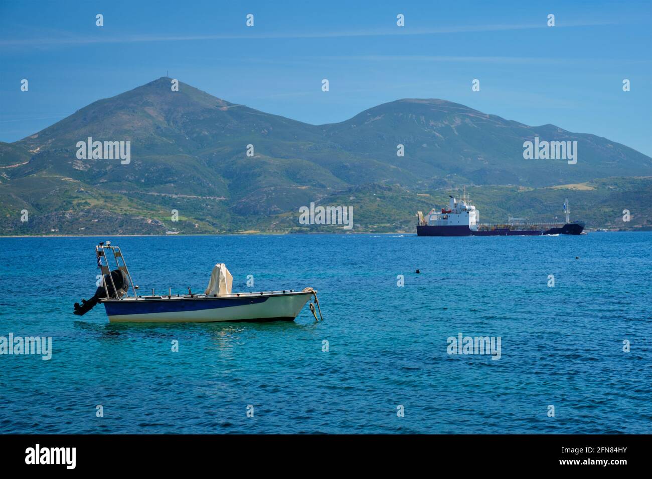 Greek fishing speed boat and cargo ship in the Aegean sea, Greece Stock ...