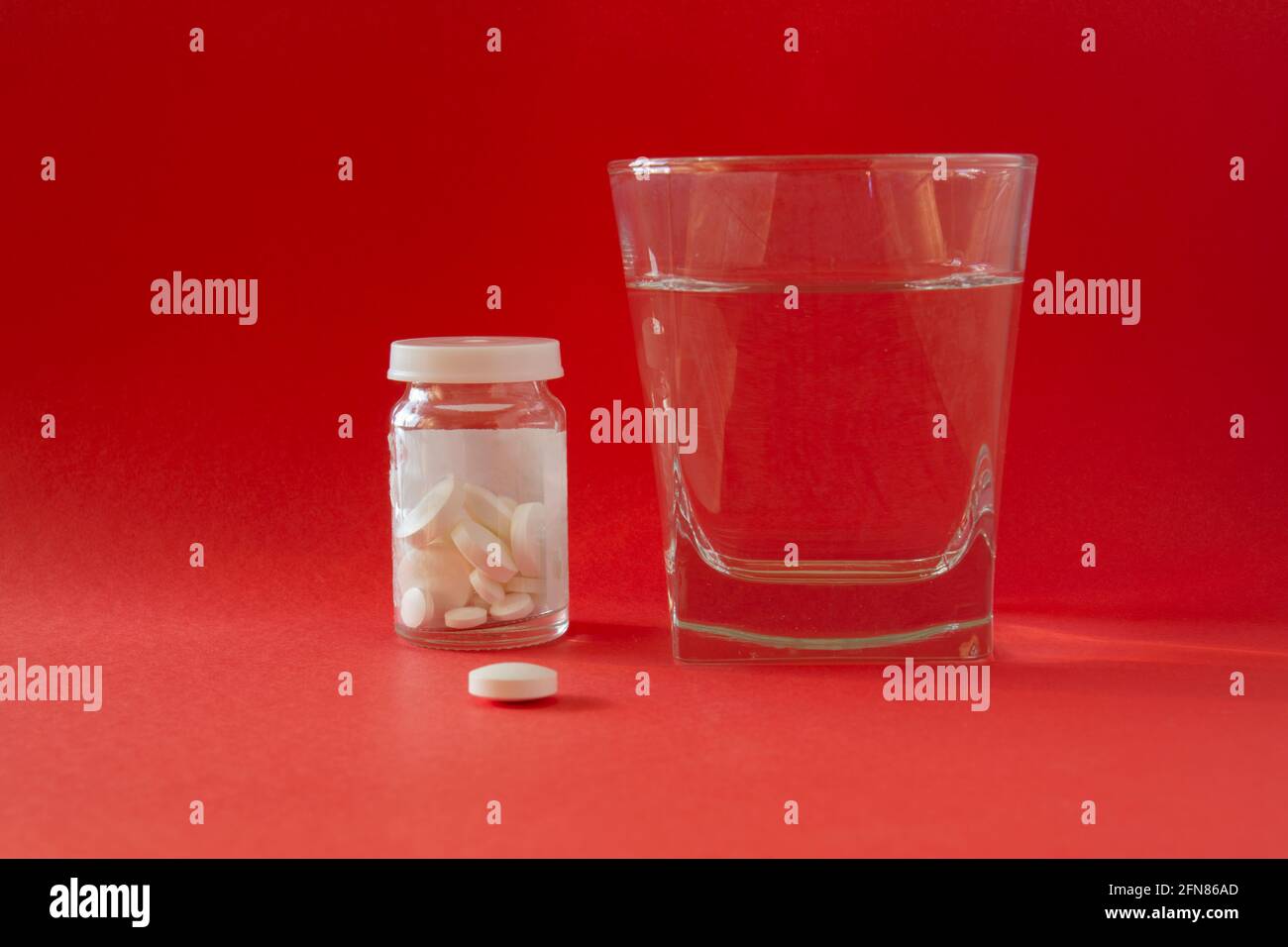 a glass of water, bottle and medicines, pills, drugs. isolated. red ...