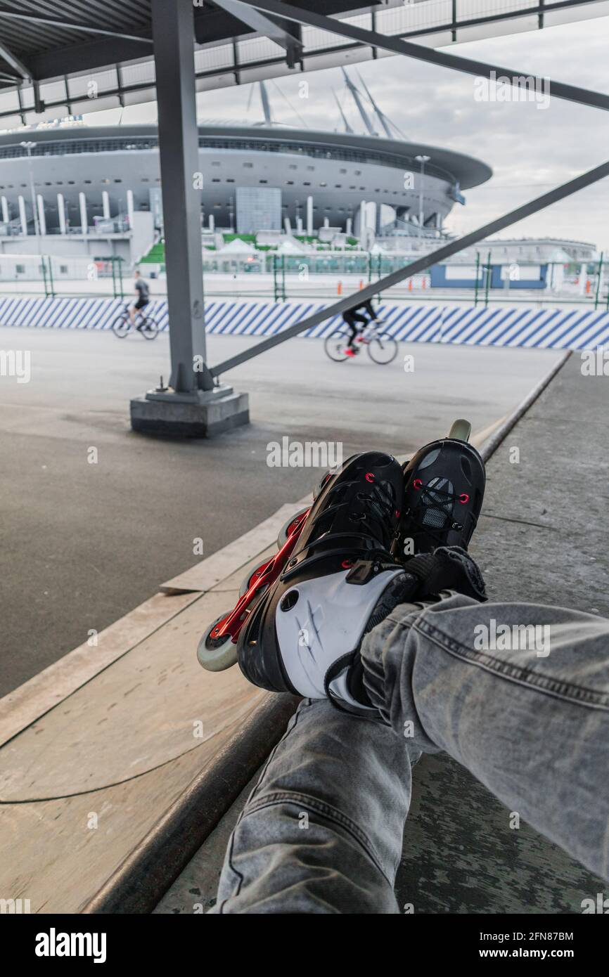 man legs in roller skates sits on a ramp in skatepark Stock Photo - Alamy