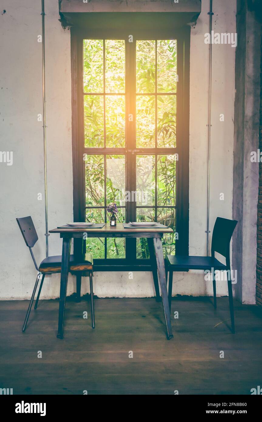 Dining room interior. Loft-style window with nature view, cement walls ...