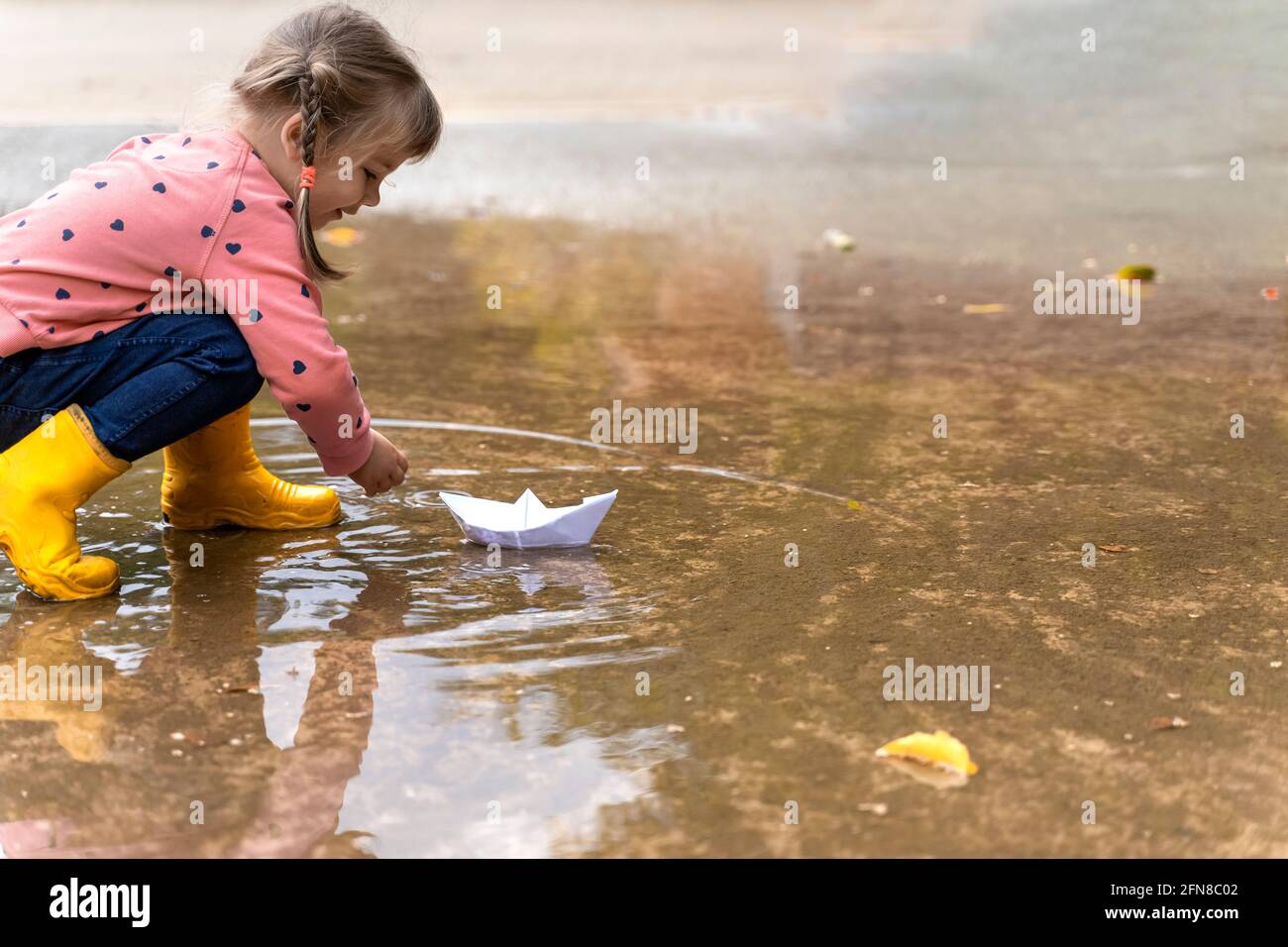 cute little girl playing with paper boat Stock Photo - Alamy