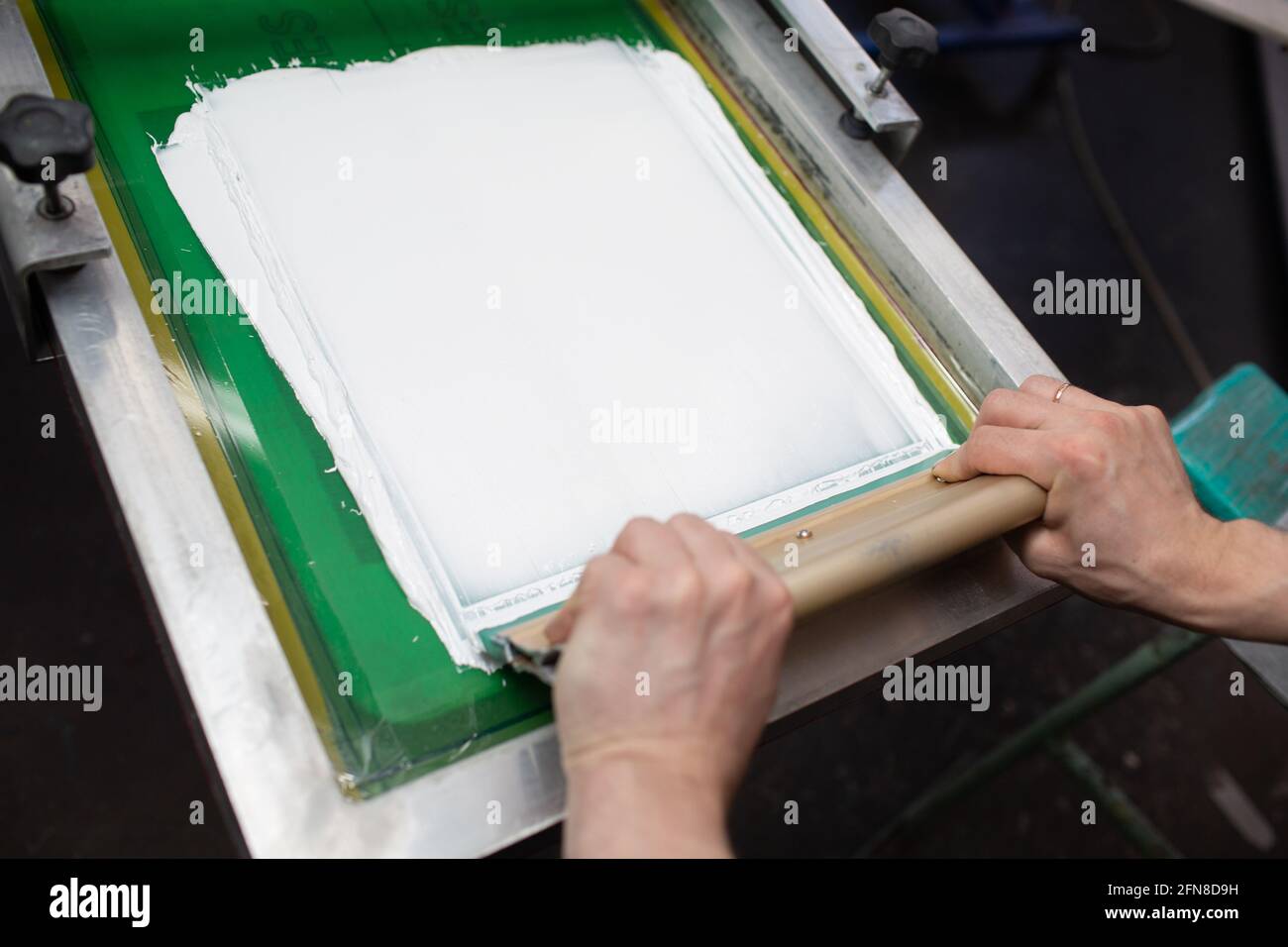 Serigraphy silk screen print at clothes factory. Frame, squeegee and ...