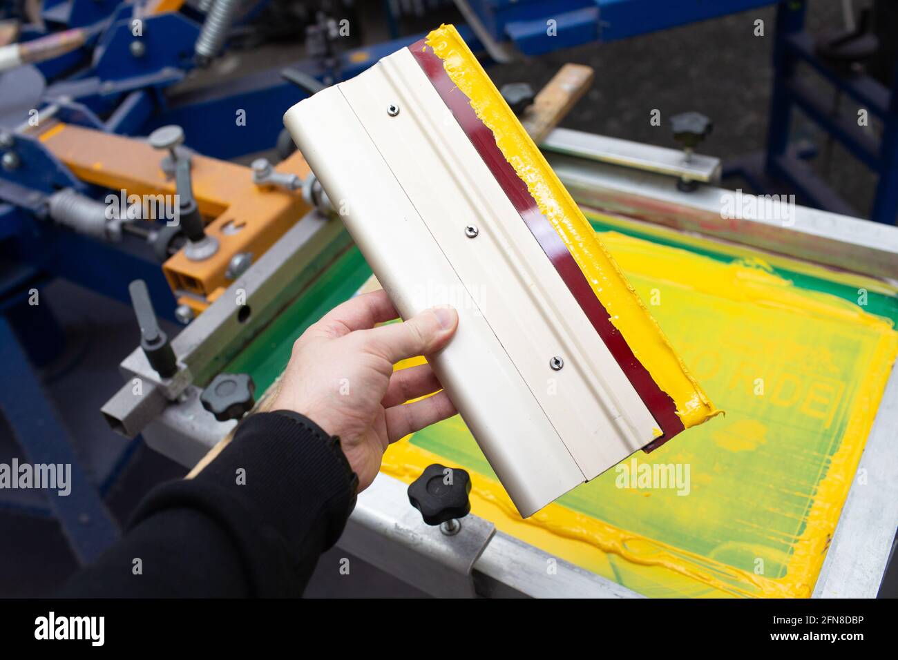 Squeegee for Serigraphy silk screen print process in hand at clothes ...