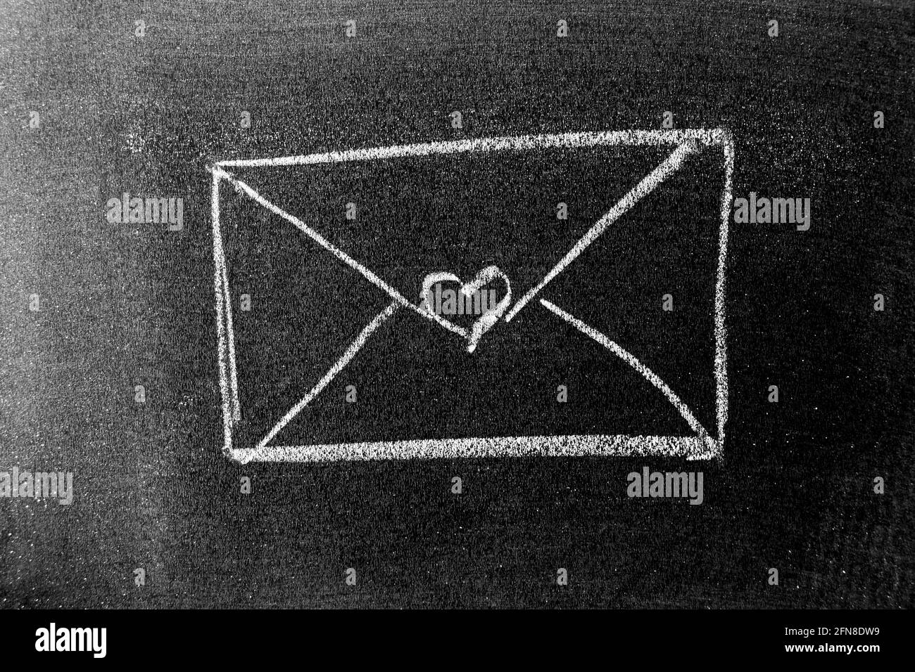 White color chalk drawing in mail envelope with heart shape on ...