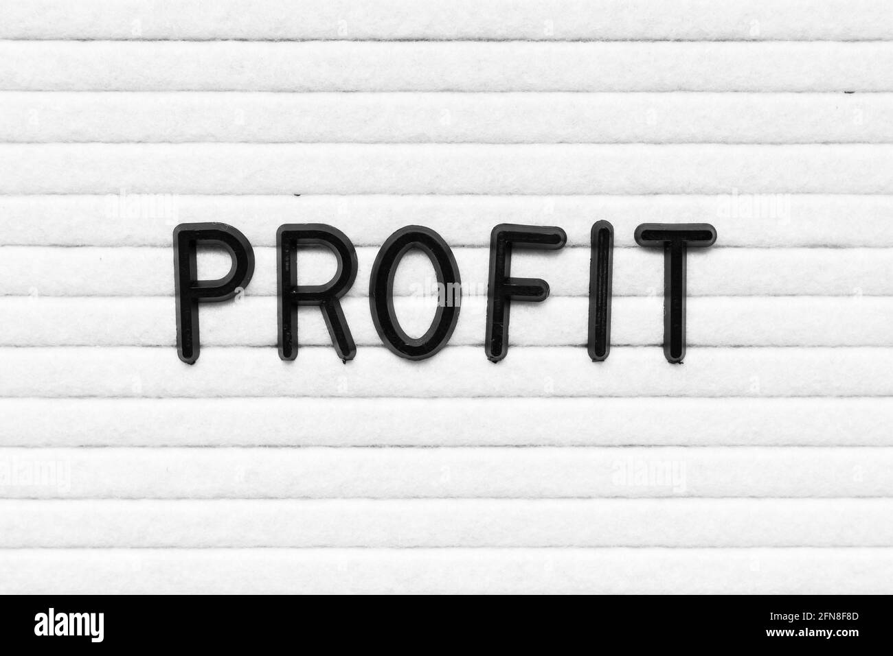 Black alphabet letter in word profit on white felt board background ...