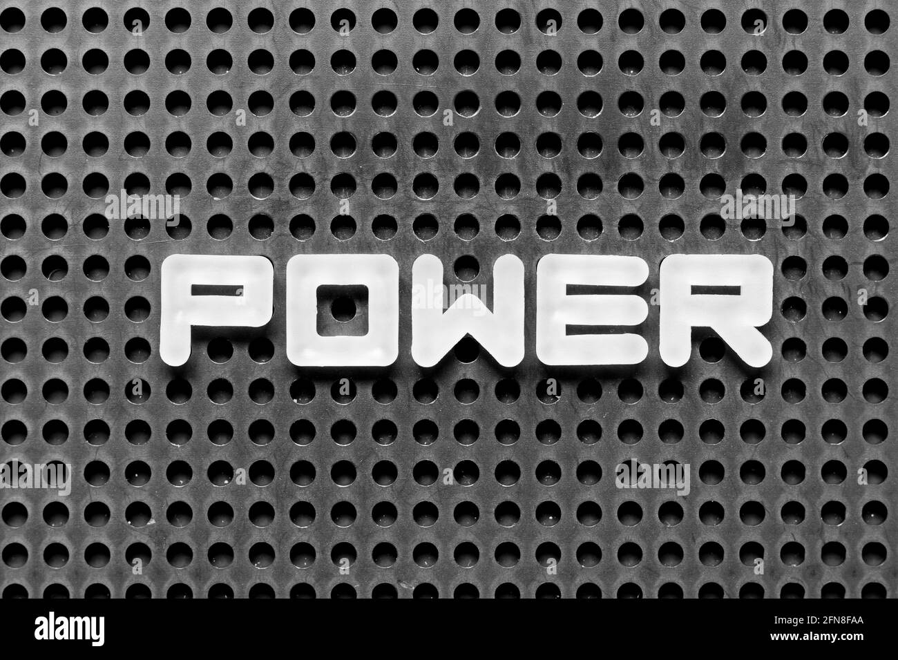 White alphabet letter in word power on black pegboard background Stock ...