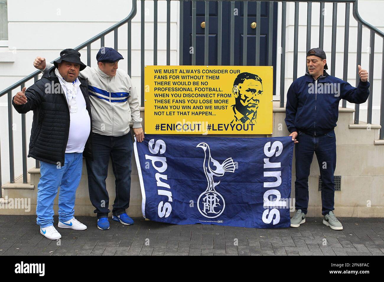Tottenham supporters hold up a flag along with a banner outside the ...
