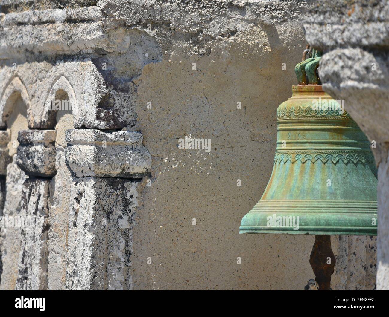 Antique handcrafted cast iron bell on the ruins of the 15th century ...