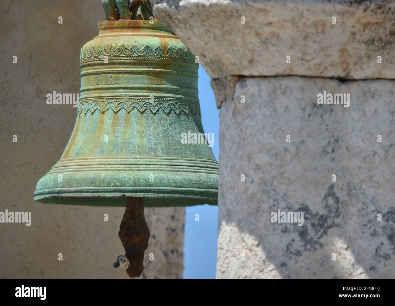Antique handcrafted cast iron bell on the ruins of the 15th century ...