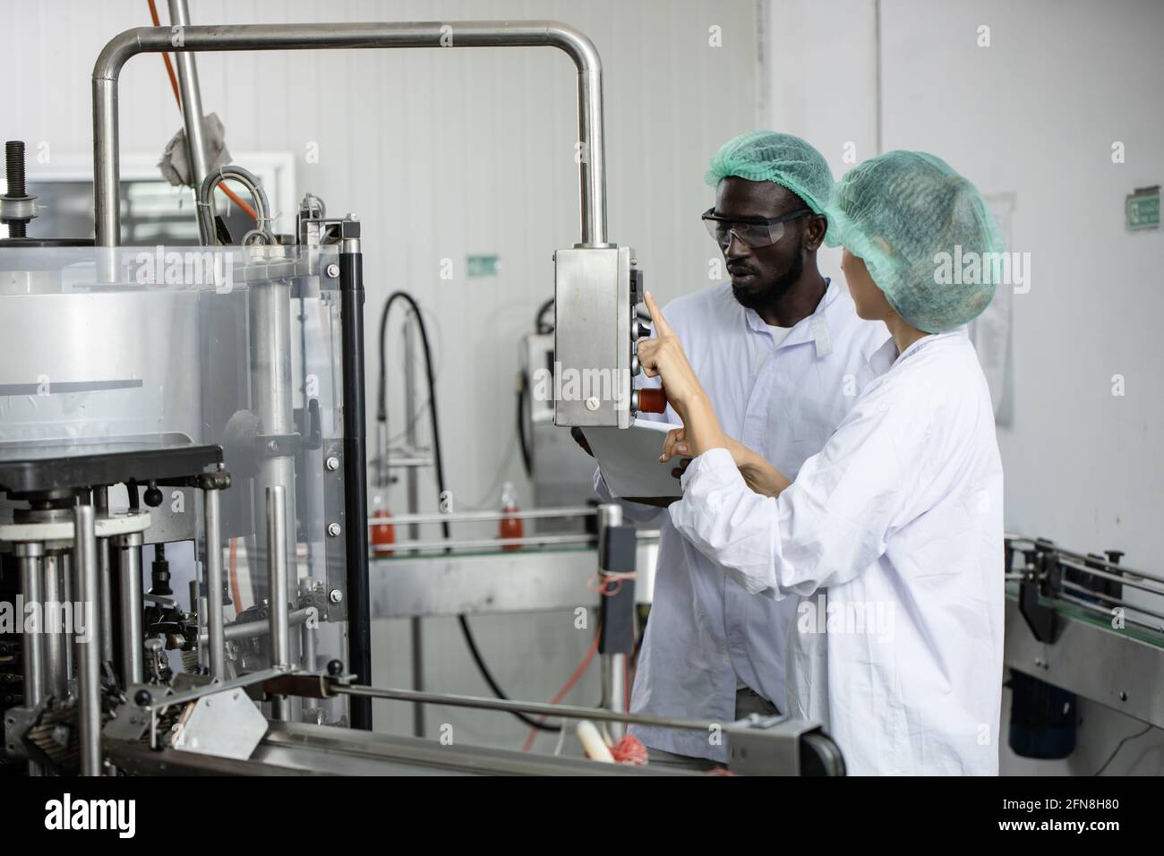 Woman staff worker working train African black man in food factory to ...