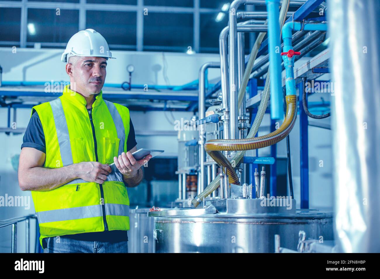 Factory worker engineer working in factory using tablet computer to ...