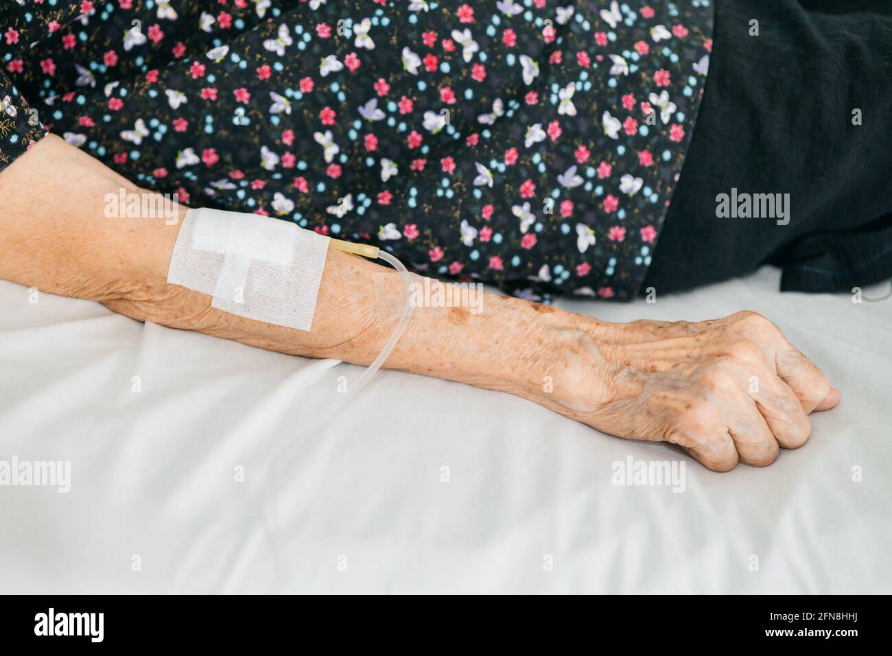 Elder arm medical treatment in hospital with drip medication through ...