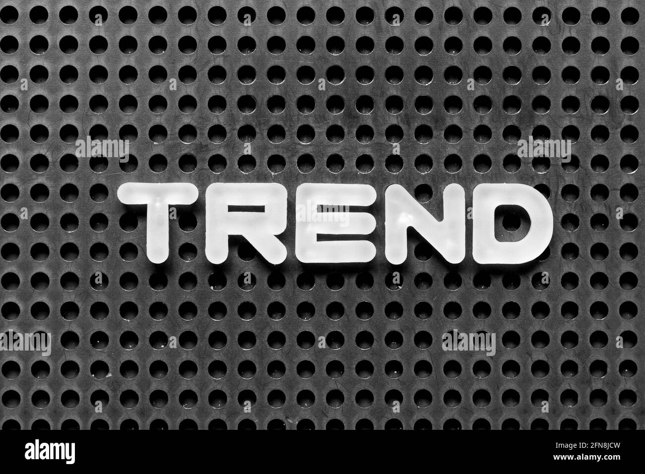 White alphabet letter in word trend on black pegboard background Stock ...