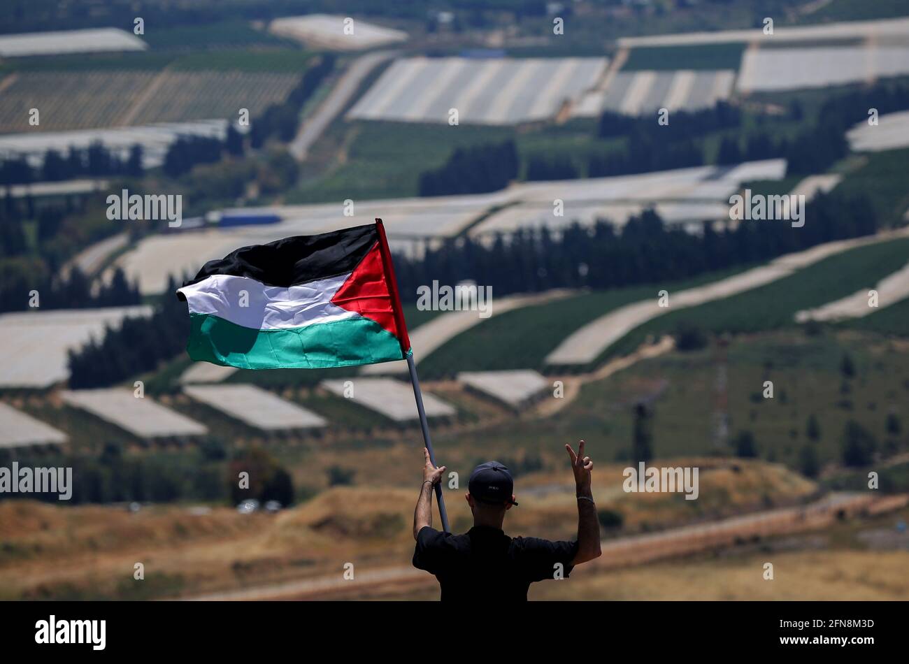 Maroun Al Ras, Lebanon. 15th May, 2021. A Palestinian flying the ...