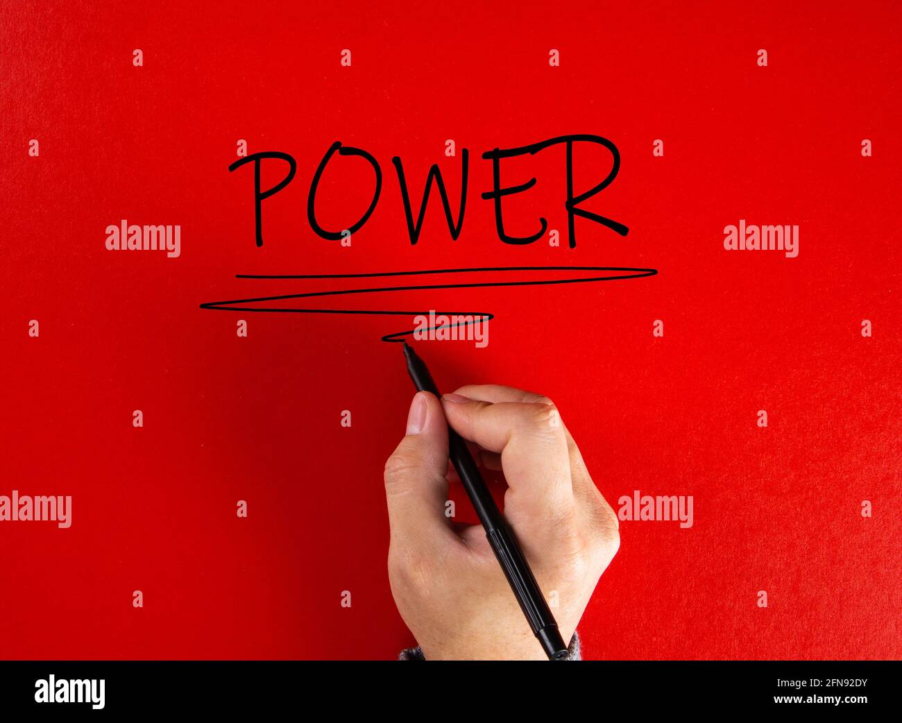 Hand writing the word power on red background. Attaining power in ...