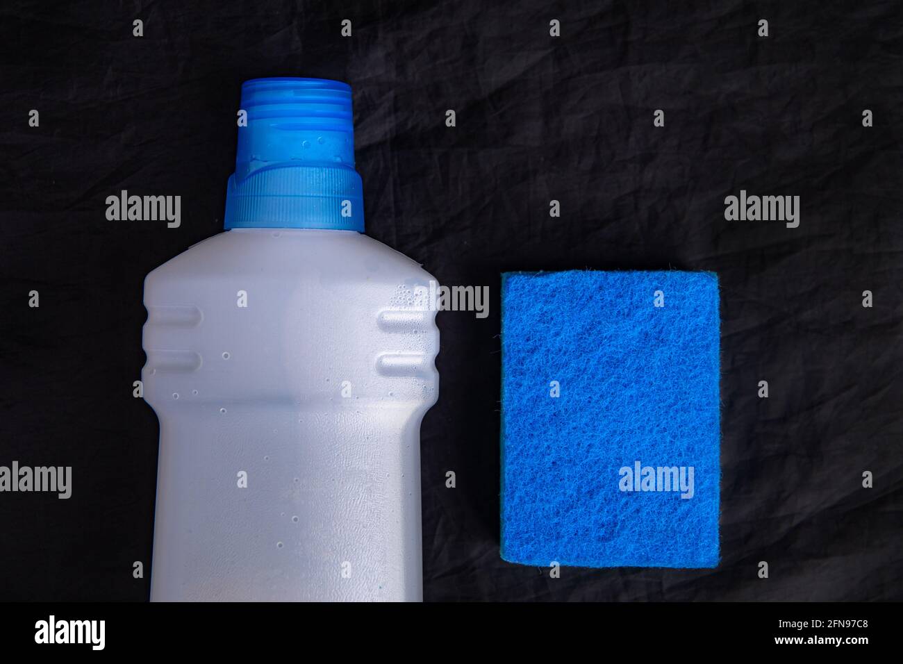 blue sponge with bottle of cleaning agent on black background Stock ...