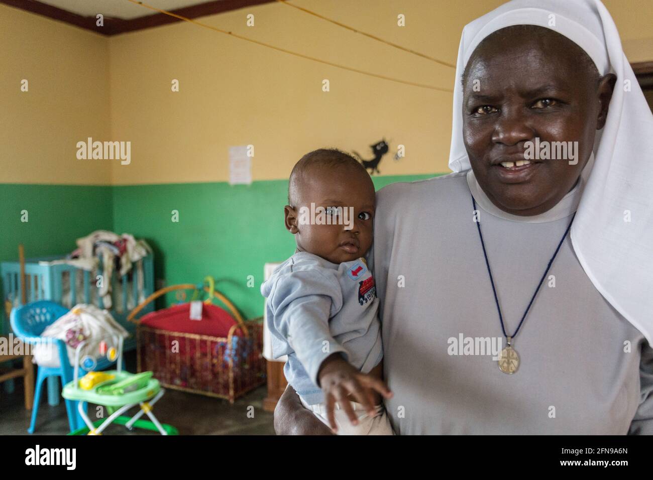 Portrait of a nun and a baby in St Kizito orphanage in rural Eastern ...