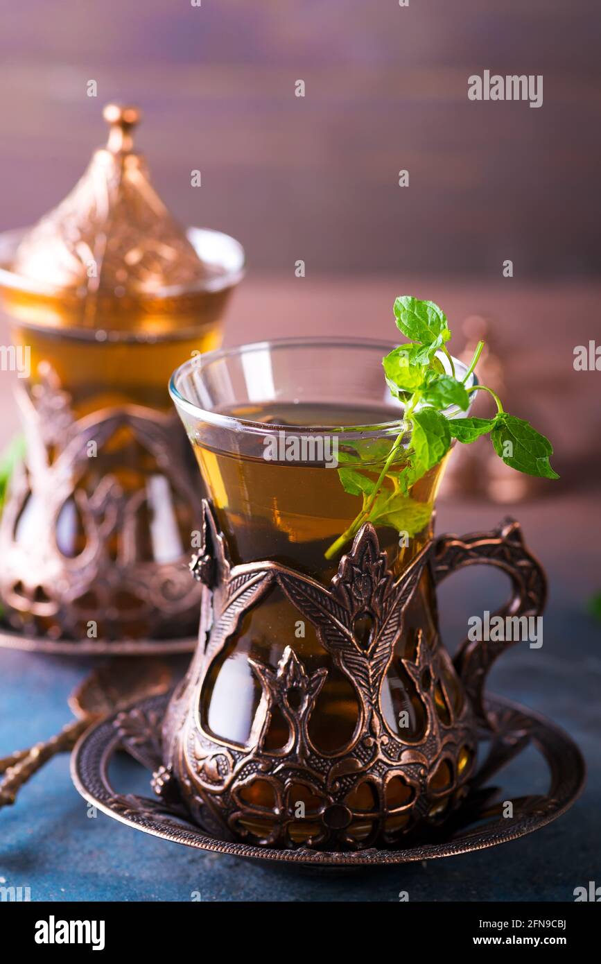 Traditional turkish tea with mint leaves in a traditional glass on ...