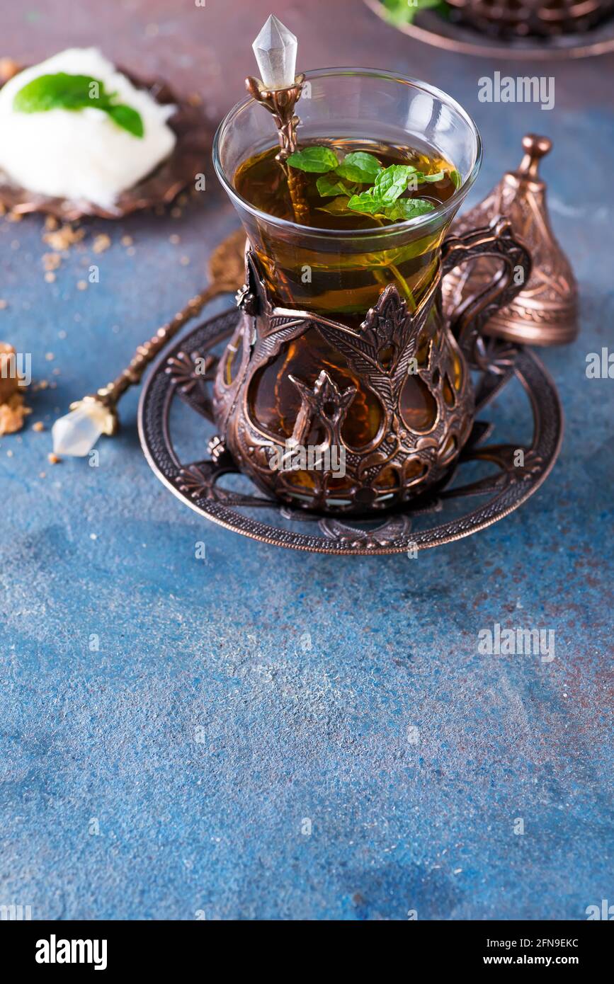 Bowl with Turkish cotton candy Pismaniye and black tea with mint on a ...