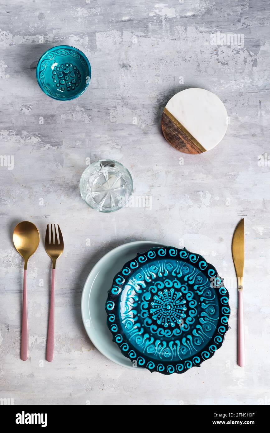 Flat lay of ceramic plate and cutlery utensils on grey background ...