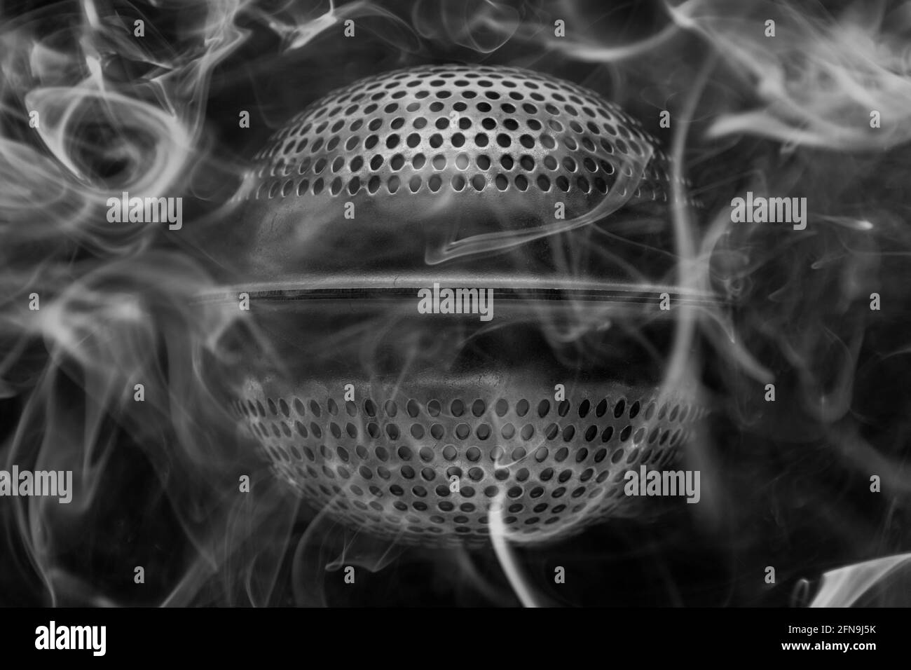 Conceptual black and white background macro photo of a tea infuser with ...