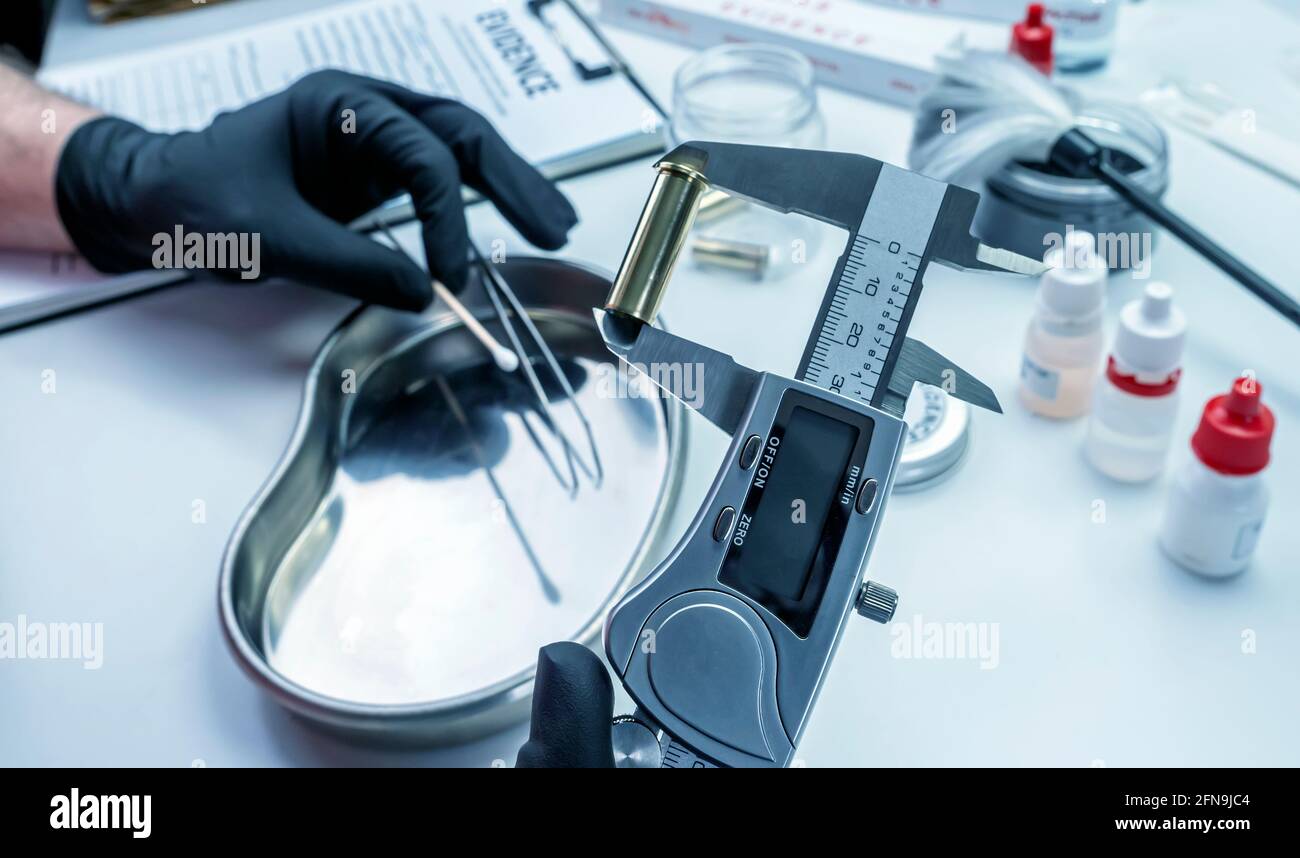 Scientific police examining a bullet cap in ballistic Laboratory ...