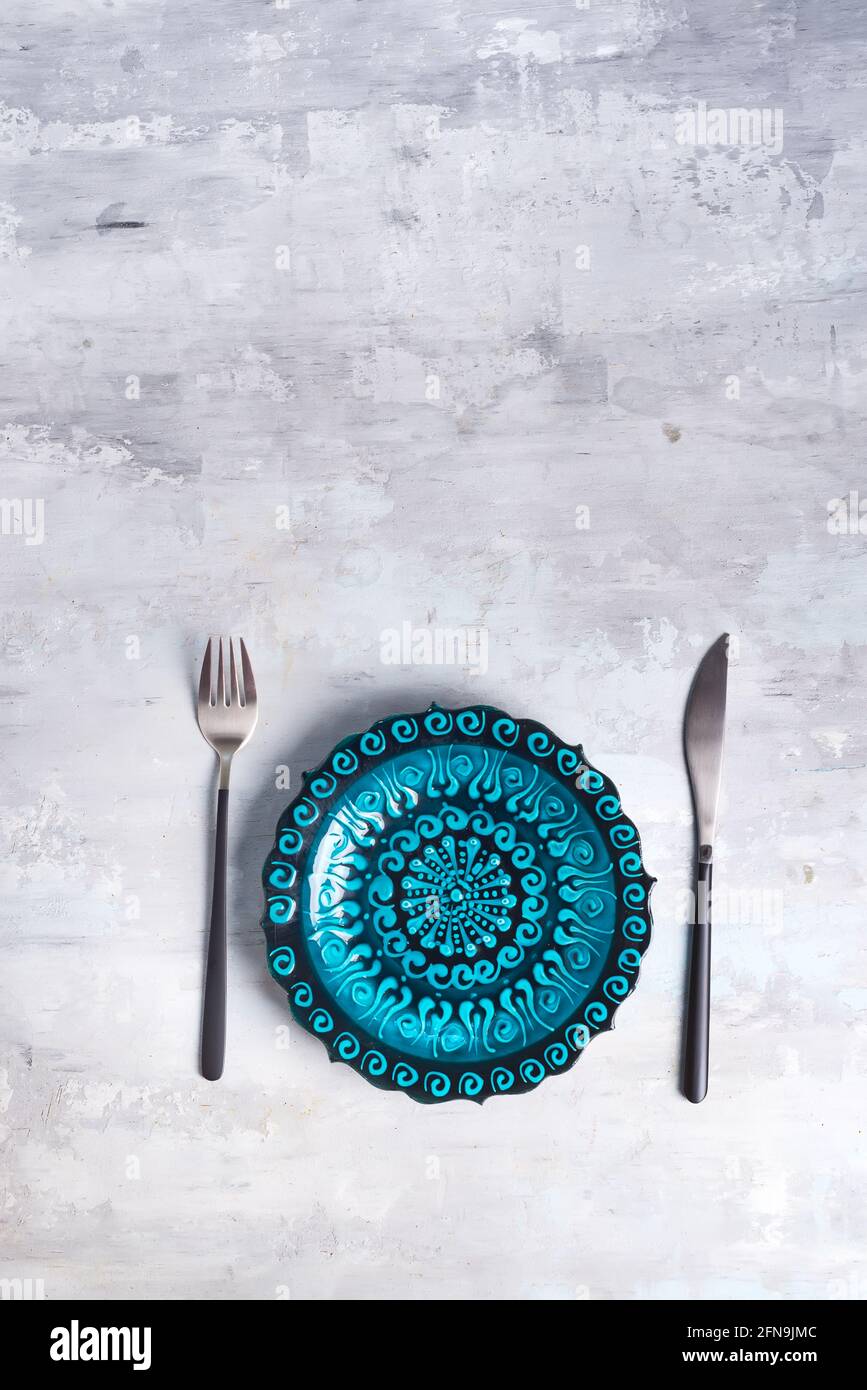 Turkish ceramics decorated blue plate with new luxury black cutlery on ...