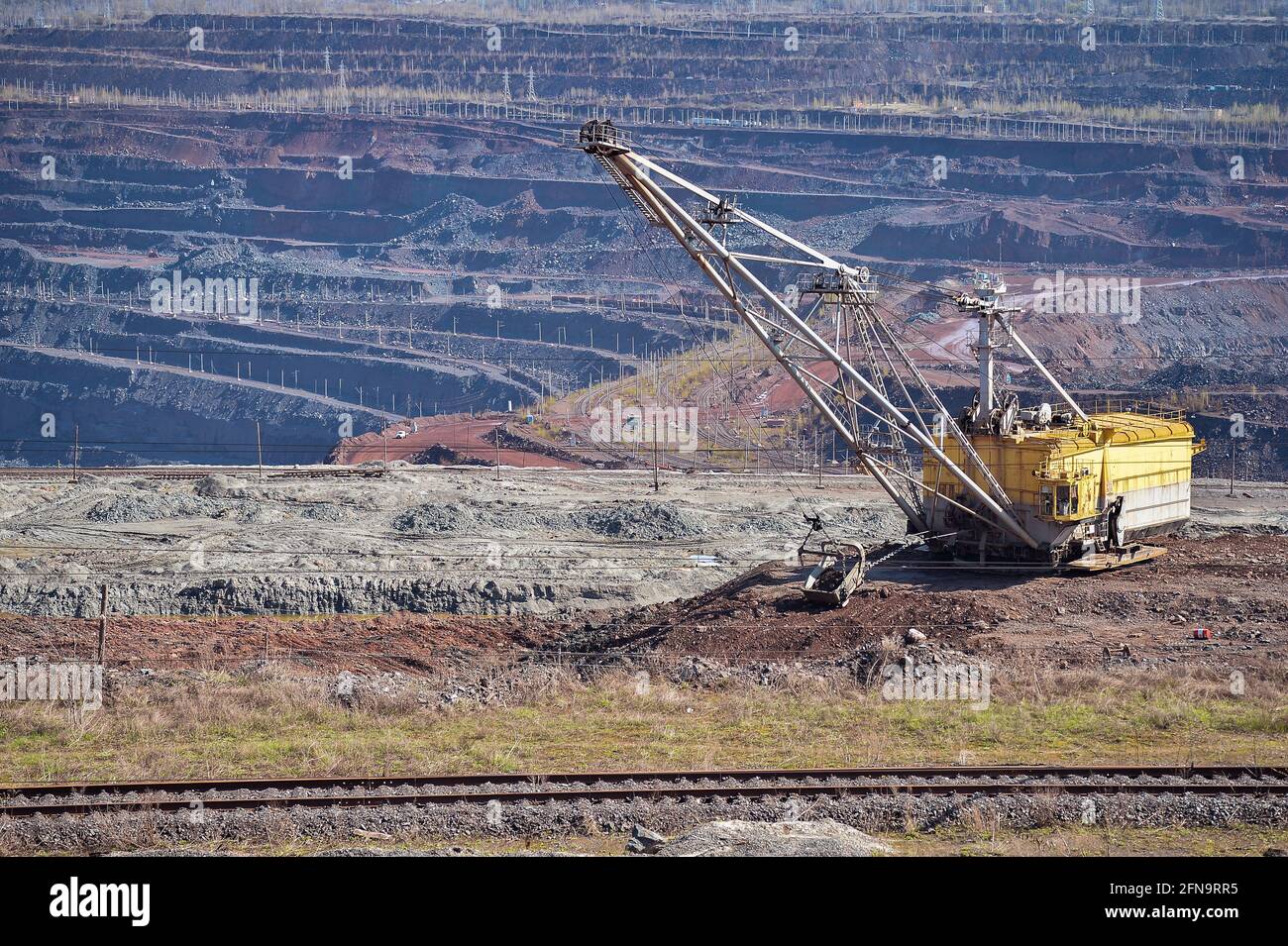 Walking excavator, railway track on the background of part of the iron ...
