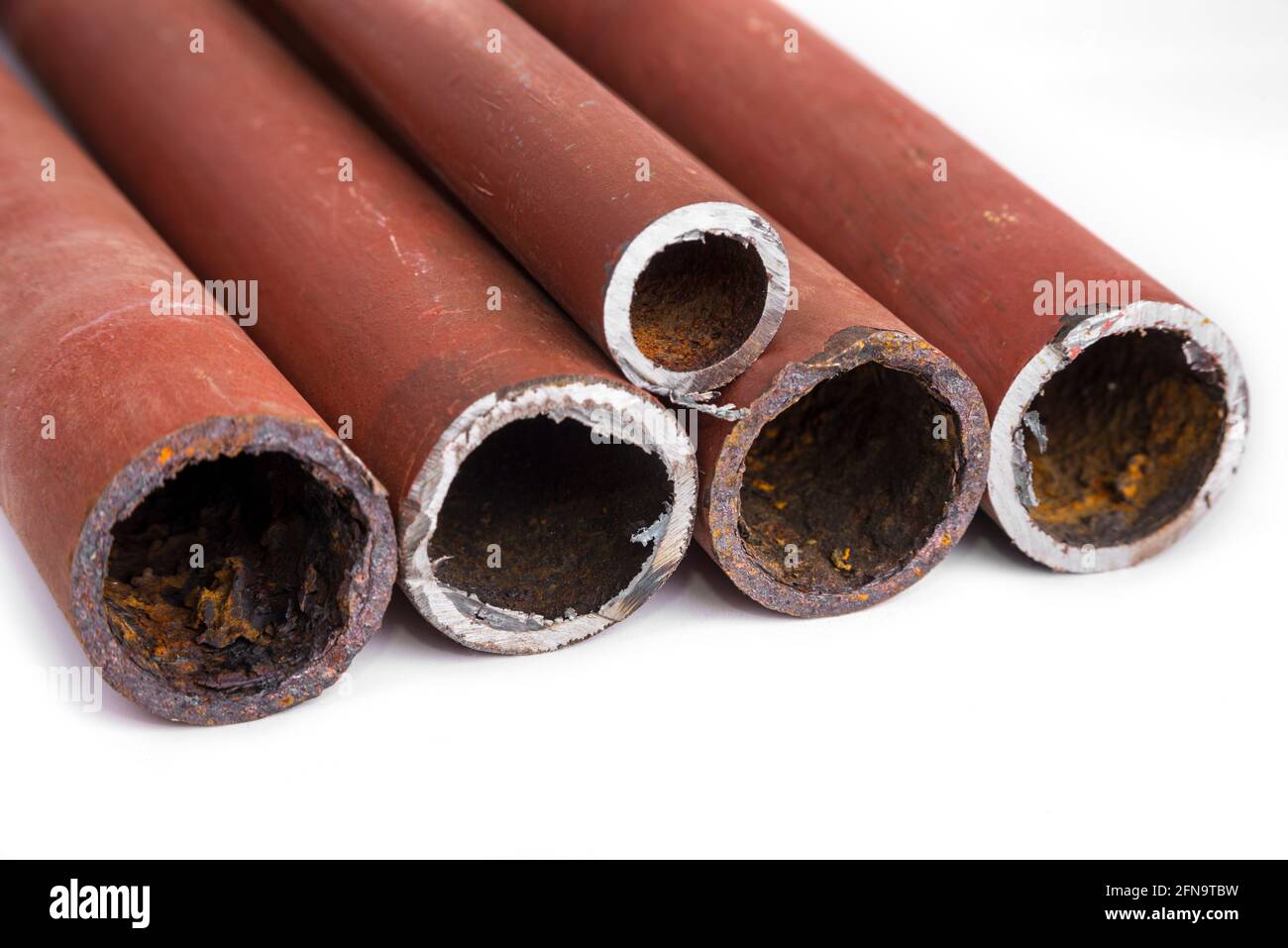 Used rusty metal thick pipes on a white Stock Photo - Alamy