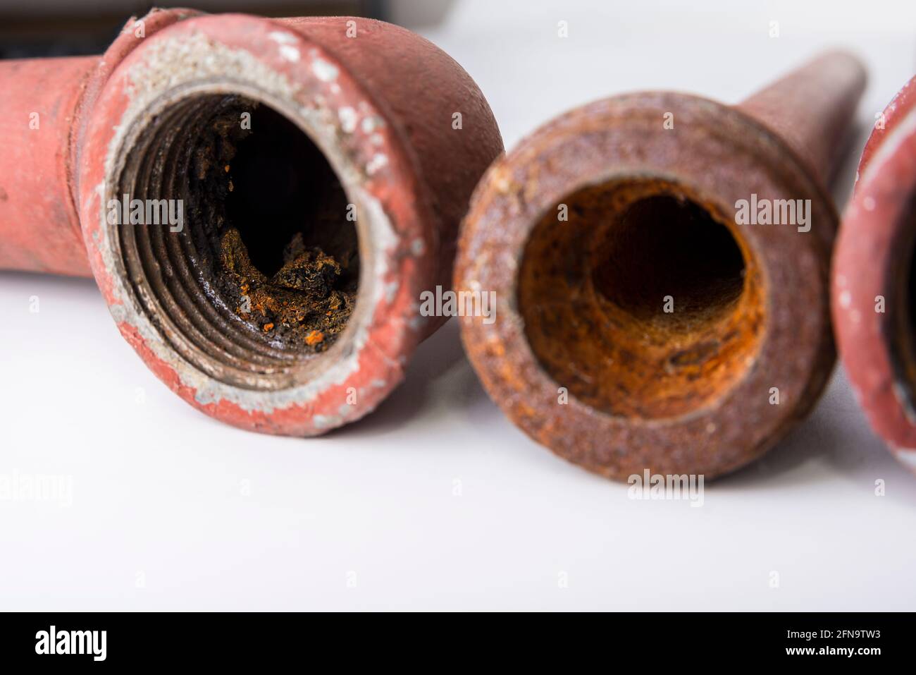 Used rusty metal thick pipes on a white Stock Photo - Alamy