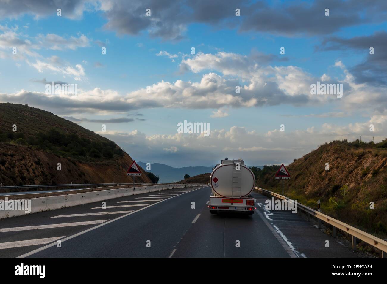 Fuel tanker truck driving on the highway and approaching a steep slope ...